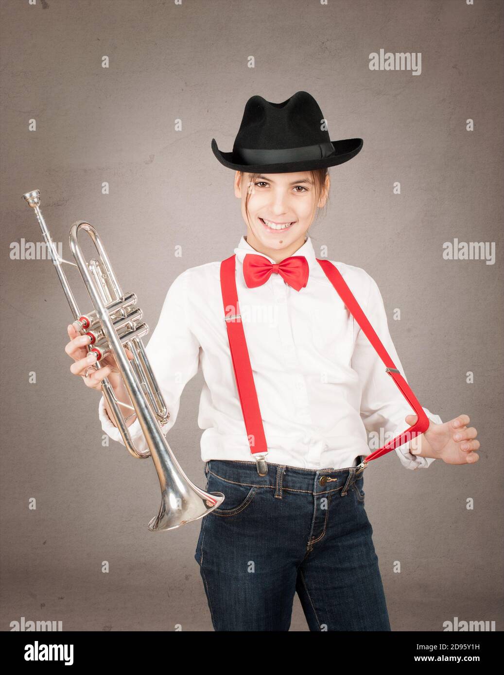 little girl playing trumpet on a gray background Stock Photo - Alamy