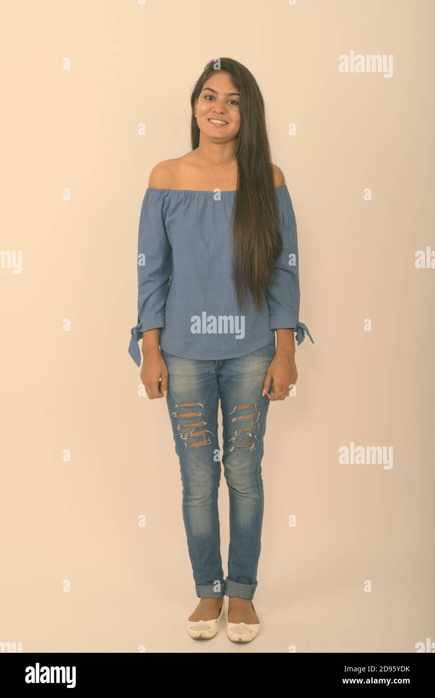 Full body shot of young happy Indian woman smiling and standing against ...