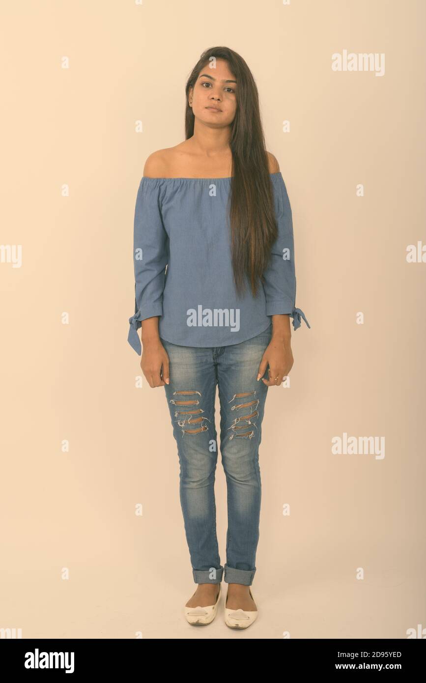 Full body shot of young Indian woman standing against white background ...