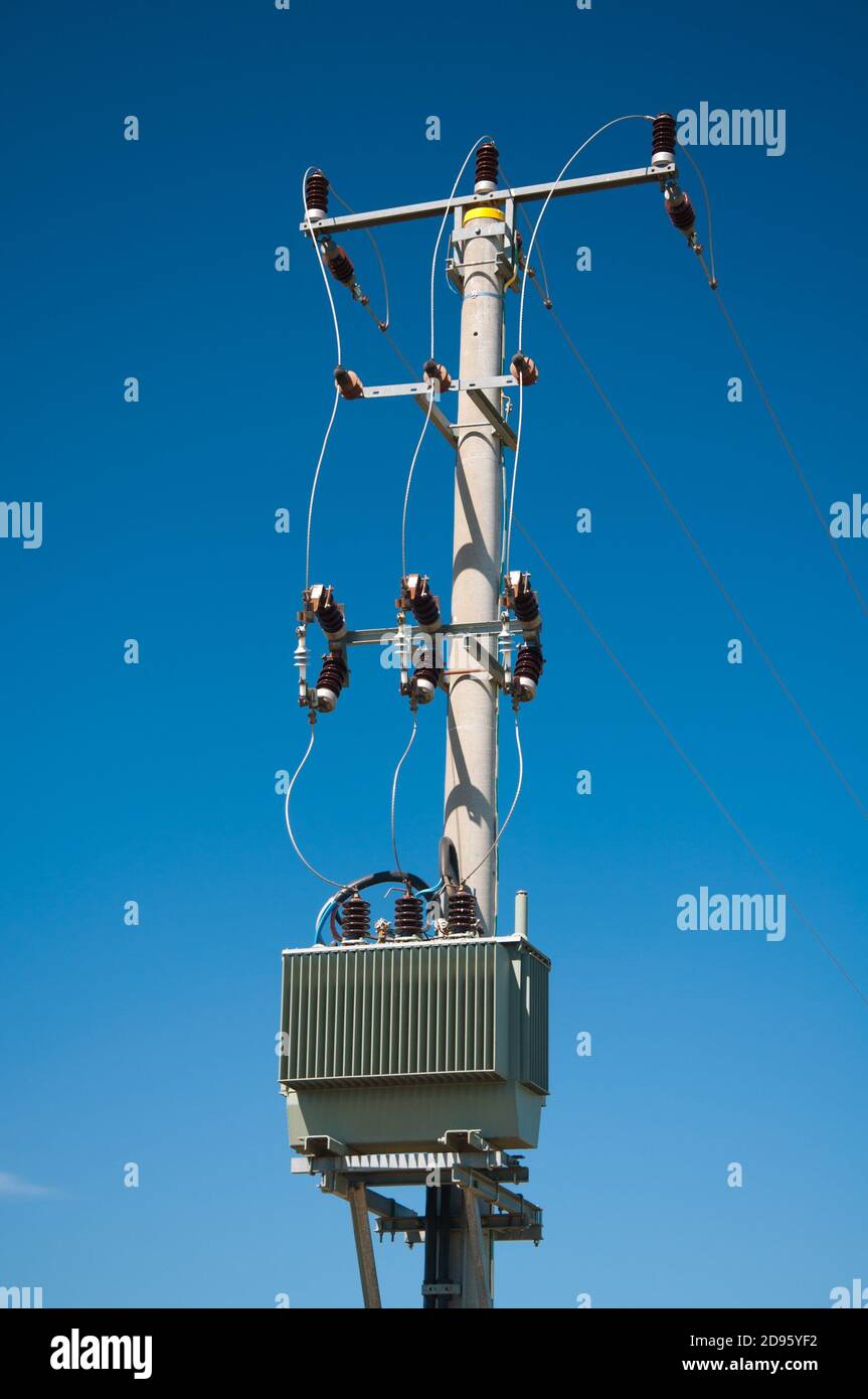 electric pylon with isolators on blue sky background Stock Photo - Alamy