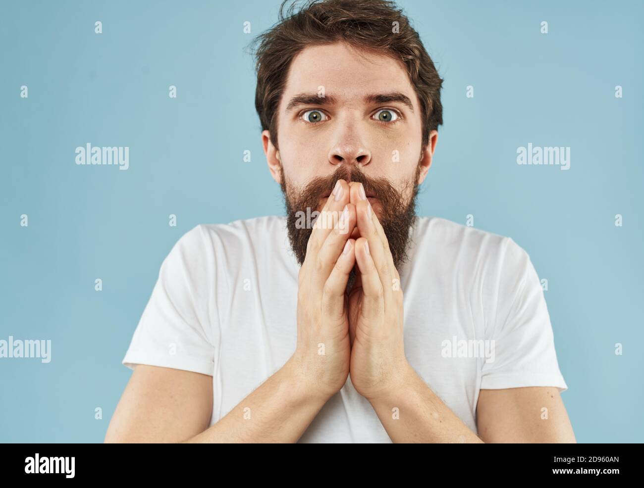 Puzzled man with a beard on a blue background emotions of surprise ...
