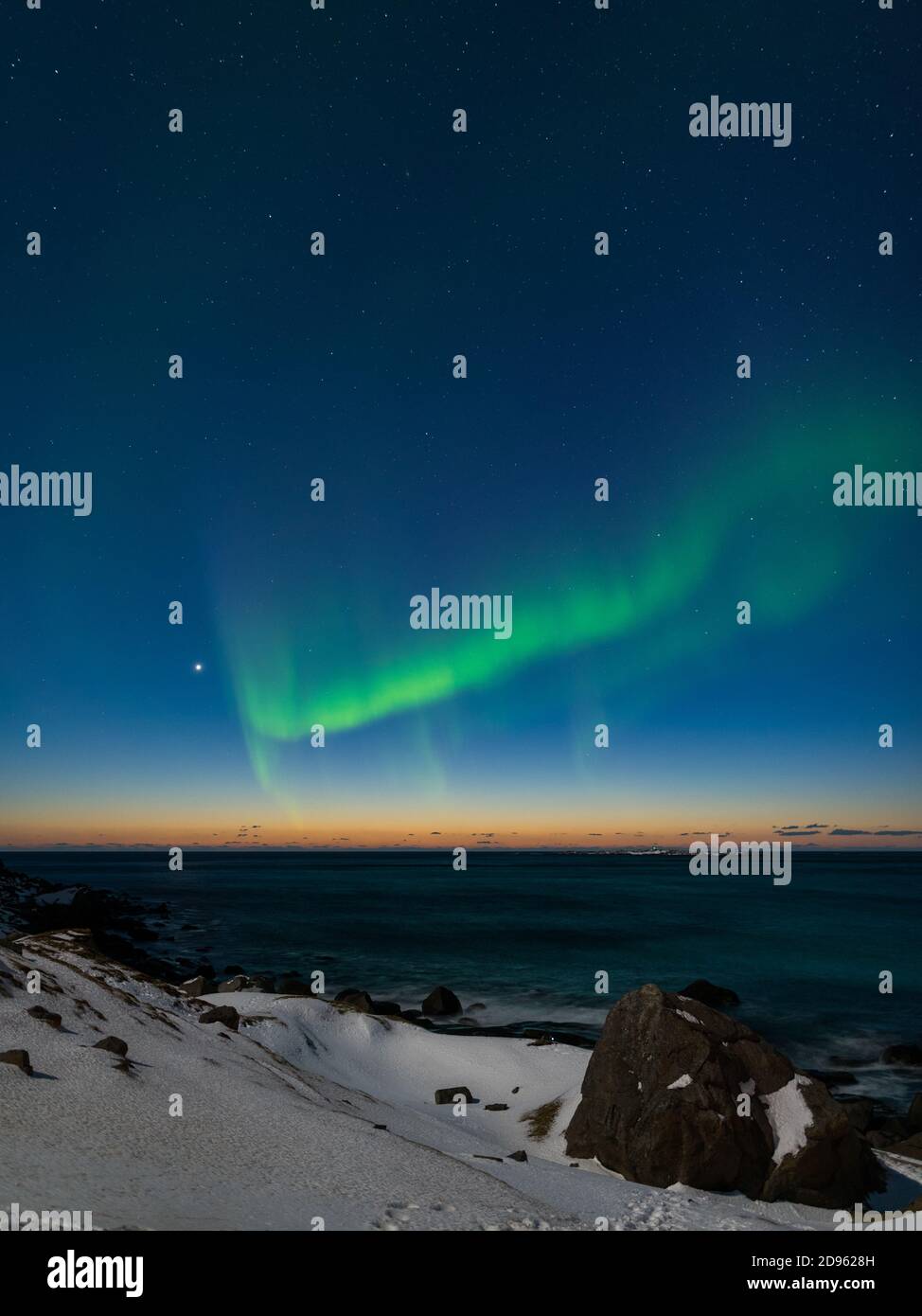 Spectacular dancing green strong northern lights over the famous round boulder beach near ...