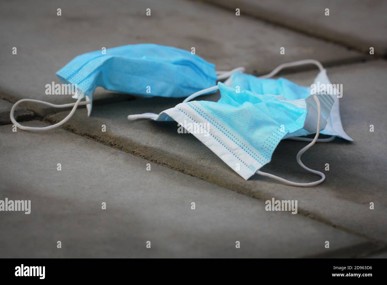 Used medical face mask thrown out on the street waste littered in the ...
