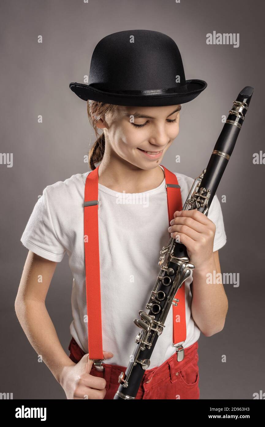 little girl playing clarinet on a gray background Stock Photo - Alamy