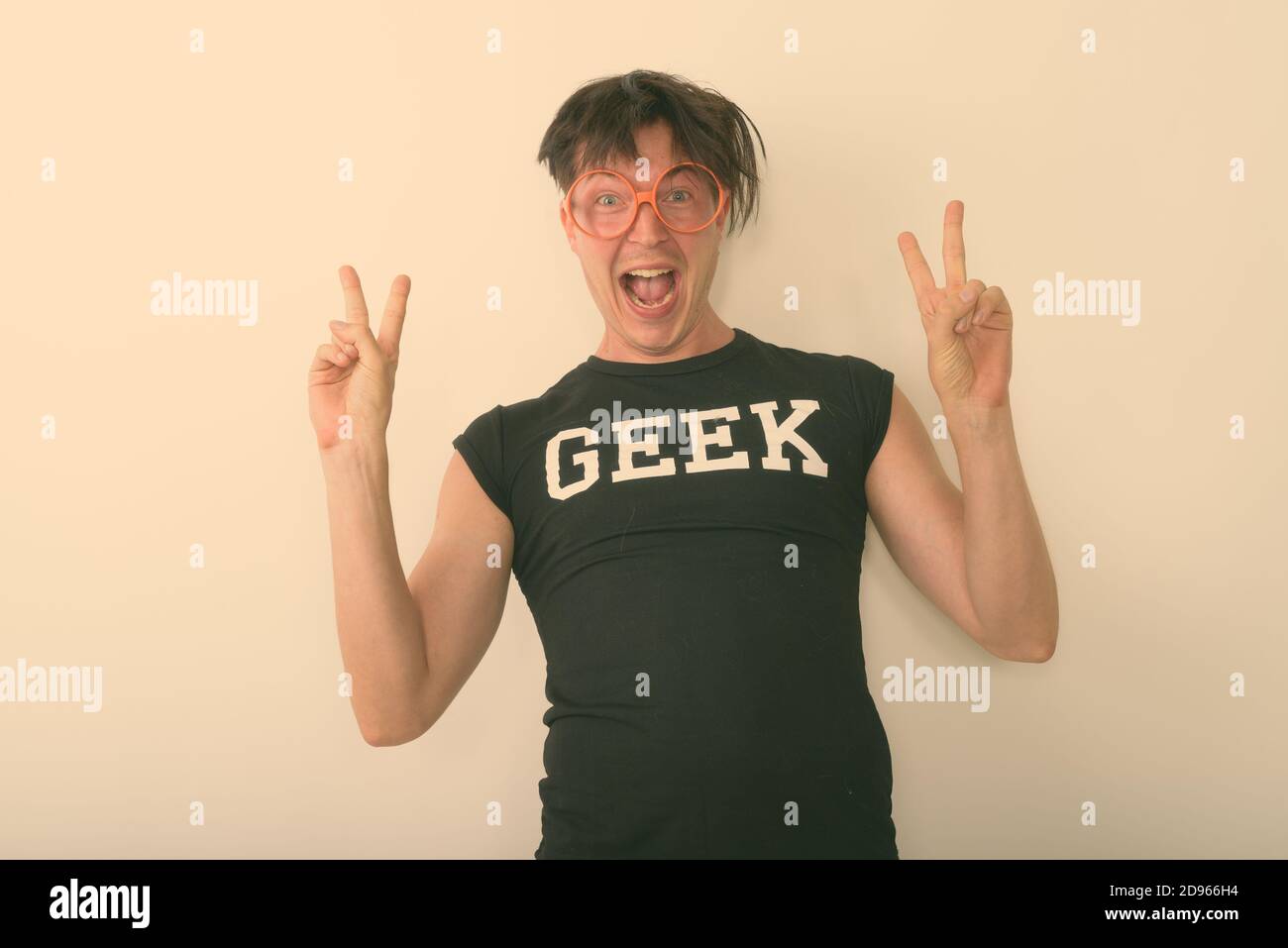 Studio shot of young happy nerd man smiling while looking excited and ...