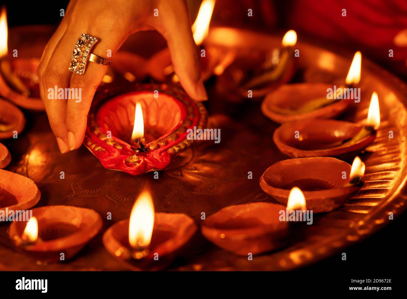 Happy Diwali background. Closeup image of female hand taking lit diya ...