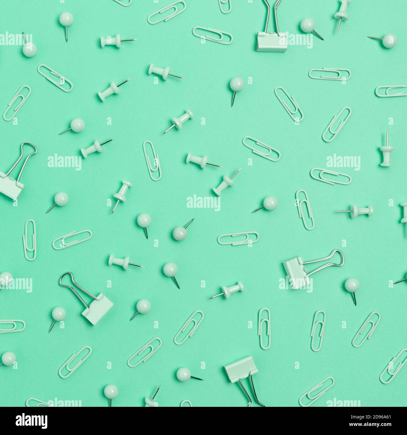 Pattern made of paper clips and push pins on mint background ...