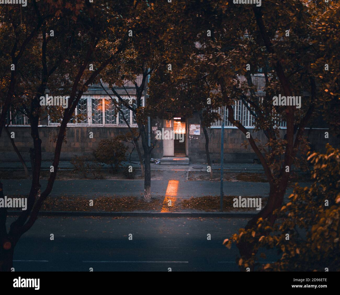 Sunset light shines through a residential building entrance door seen ...
