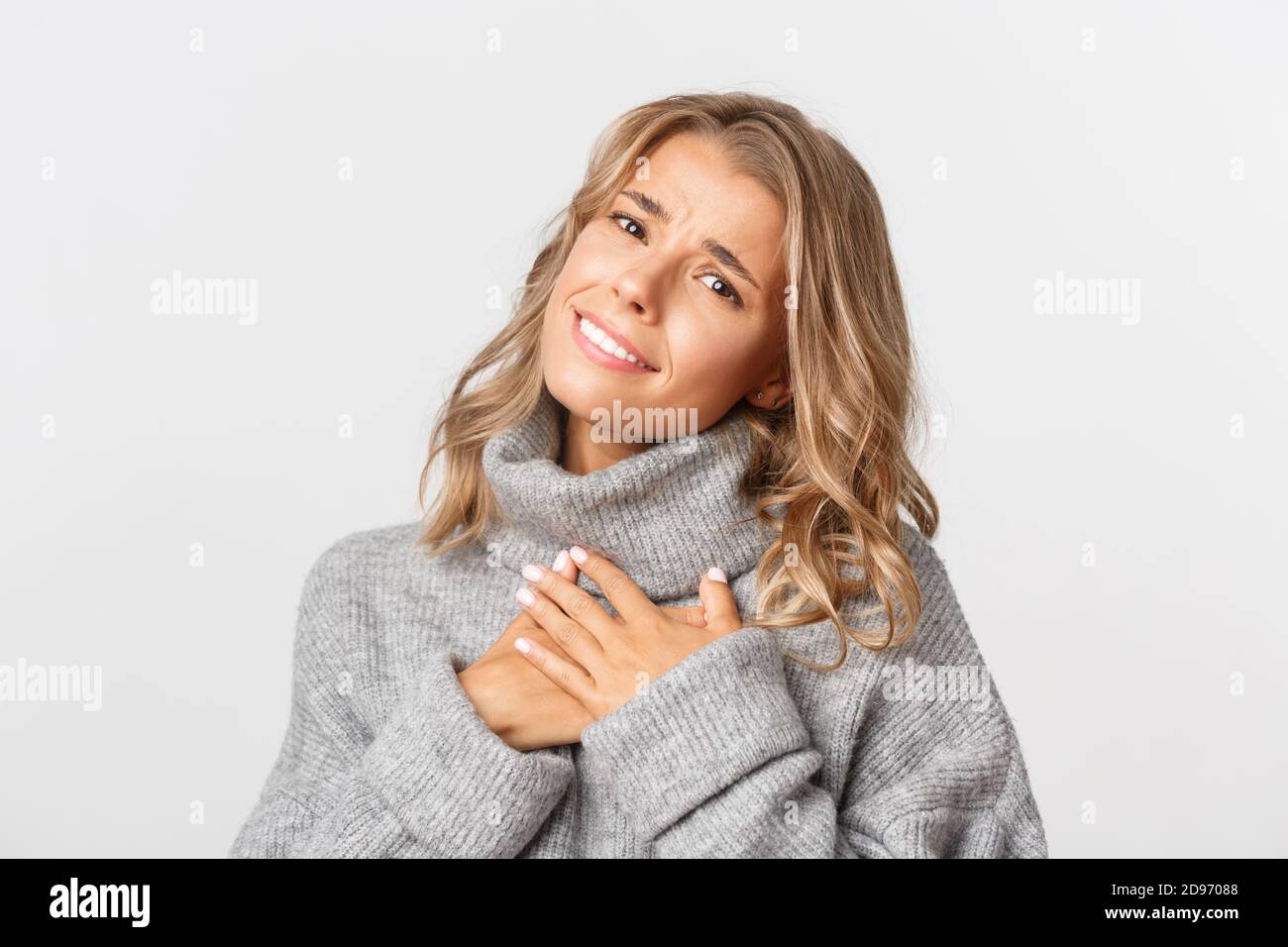 Close Up Of Beautiful Blond Girl Looking Touched And Grateful Holding
