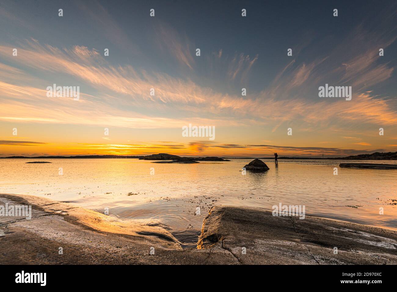 A lone fisherman fishing in shallow waters at night Stock Photo - Alamy