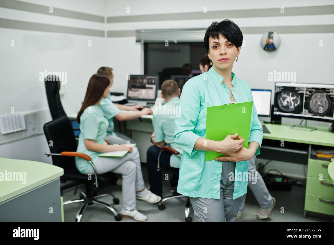 Medical theme .Portrait of female doctor with clipboard against group ...