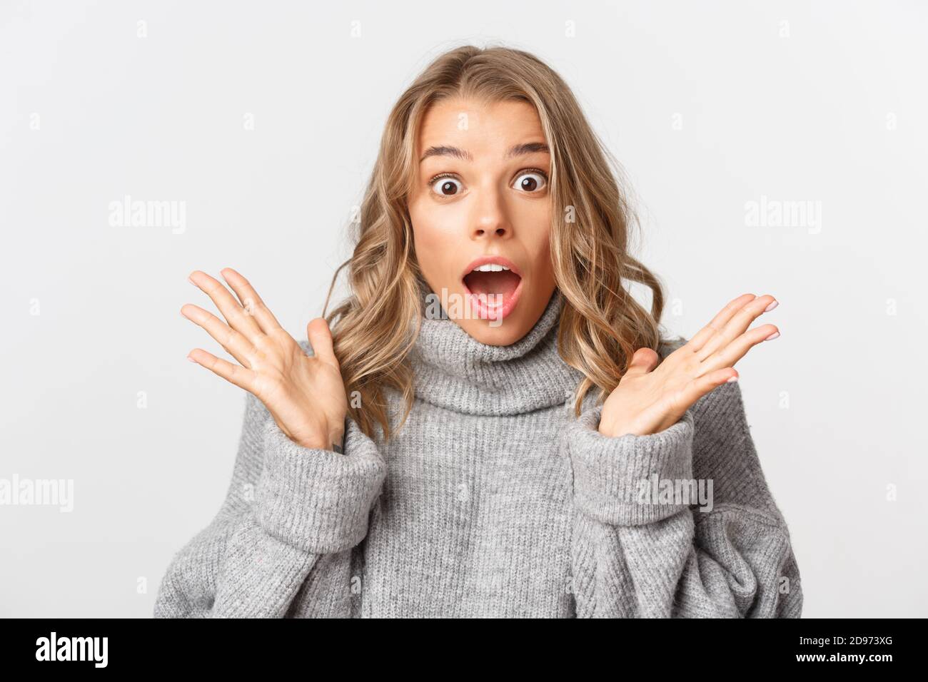 Close-up of shocked gasping girl in grey sweater, open mouth amazed ...