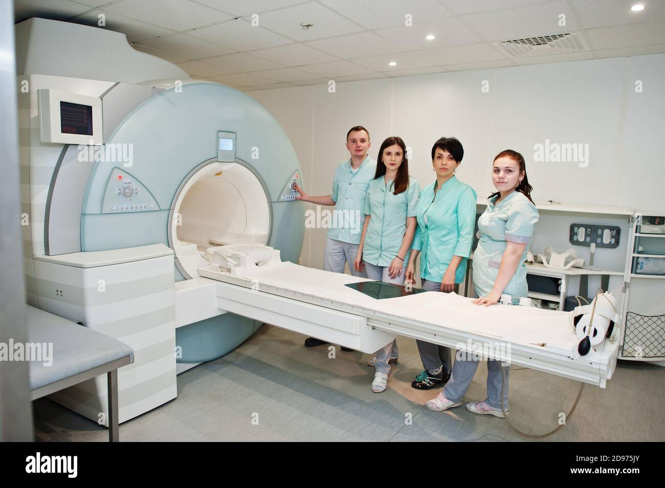 Group of doctors near magnetic resonance imaging machine at hospital ...
