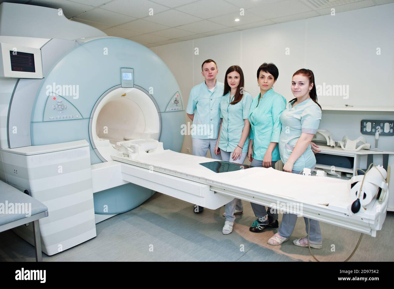 Group of doctors near magnetic resonance imaging machine at hospital ...