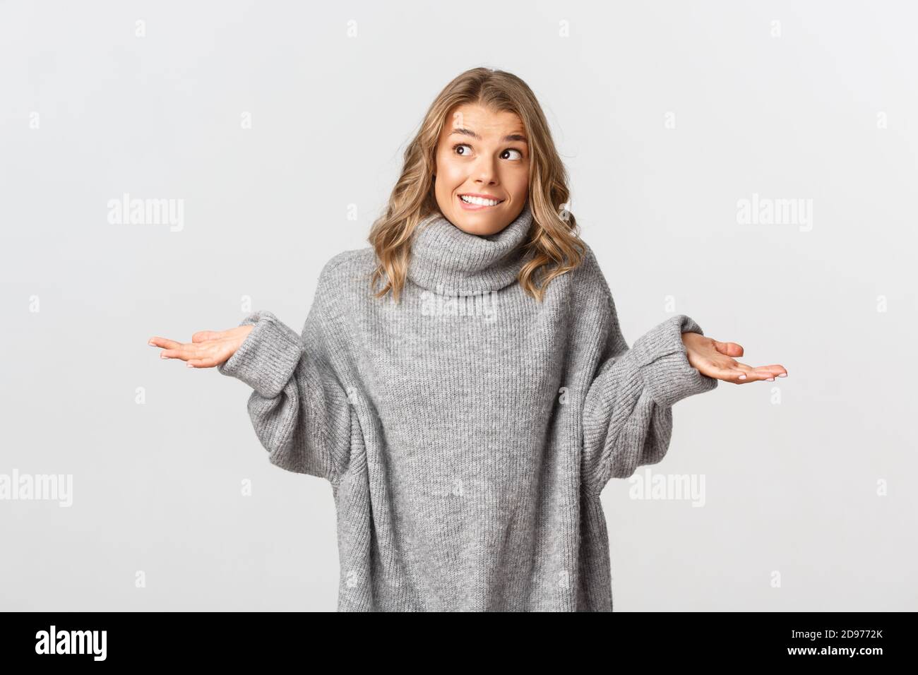 Portrait of cute and silly girl in grey sweater apologizing, shrugging ...