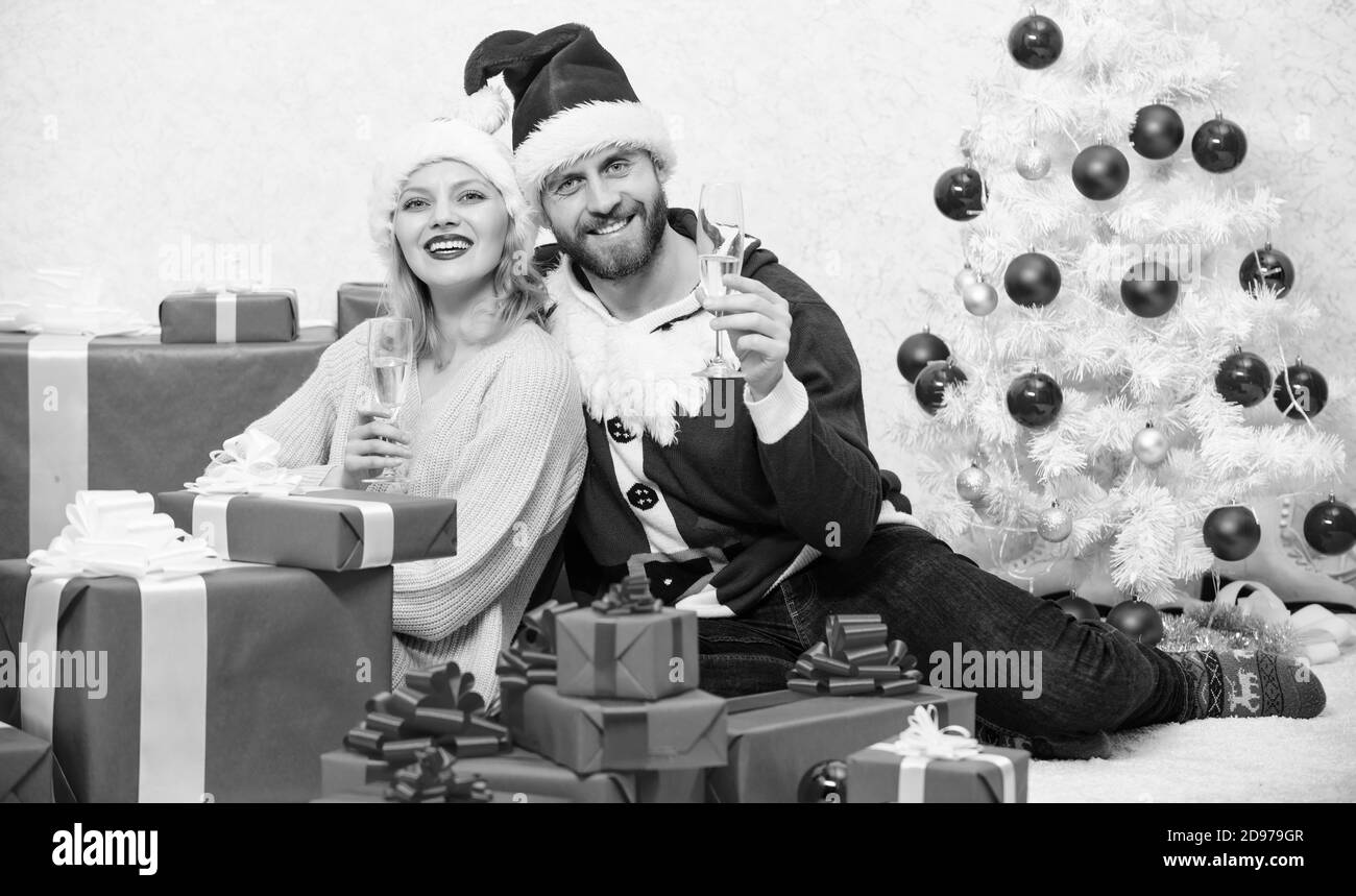 Loving couple cuddle and drink champagne near christmas tree. Couple in ...