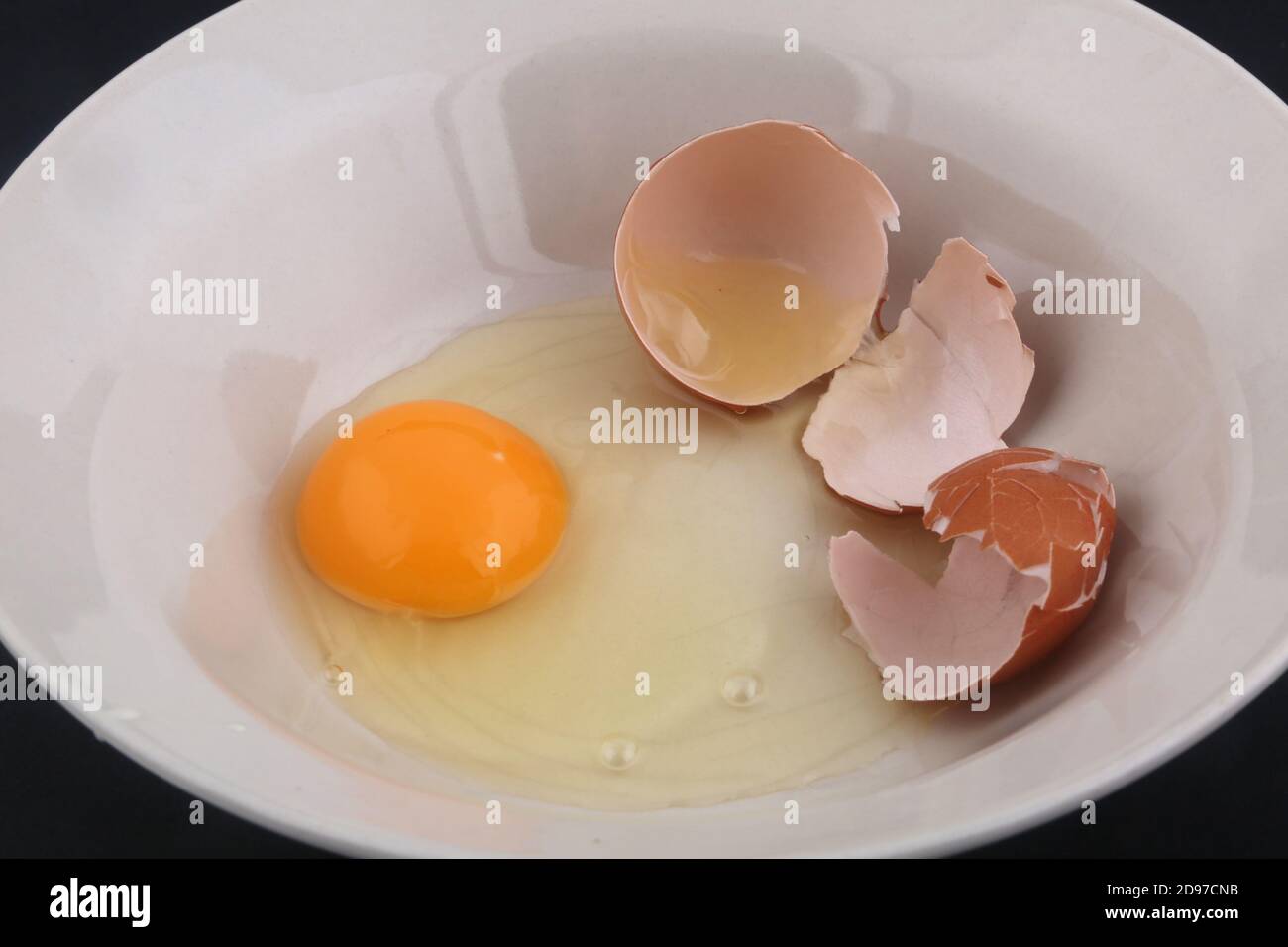 open egg with yolk ready to cook Stock Photo - Alamy