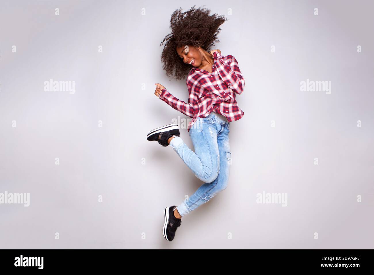 Full body portrait of cheerful young african woman jumping in air over ...