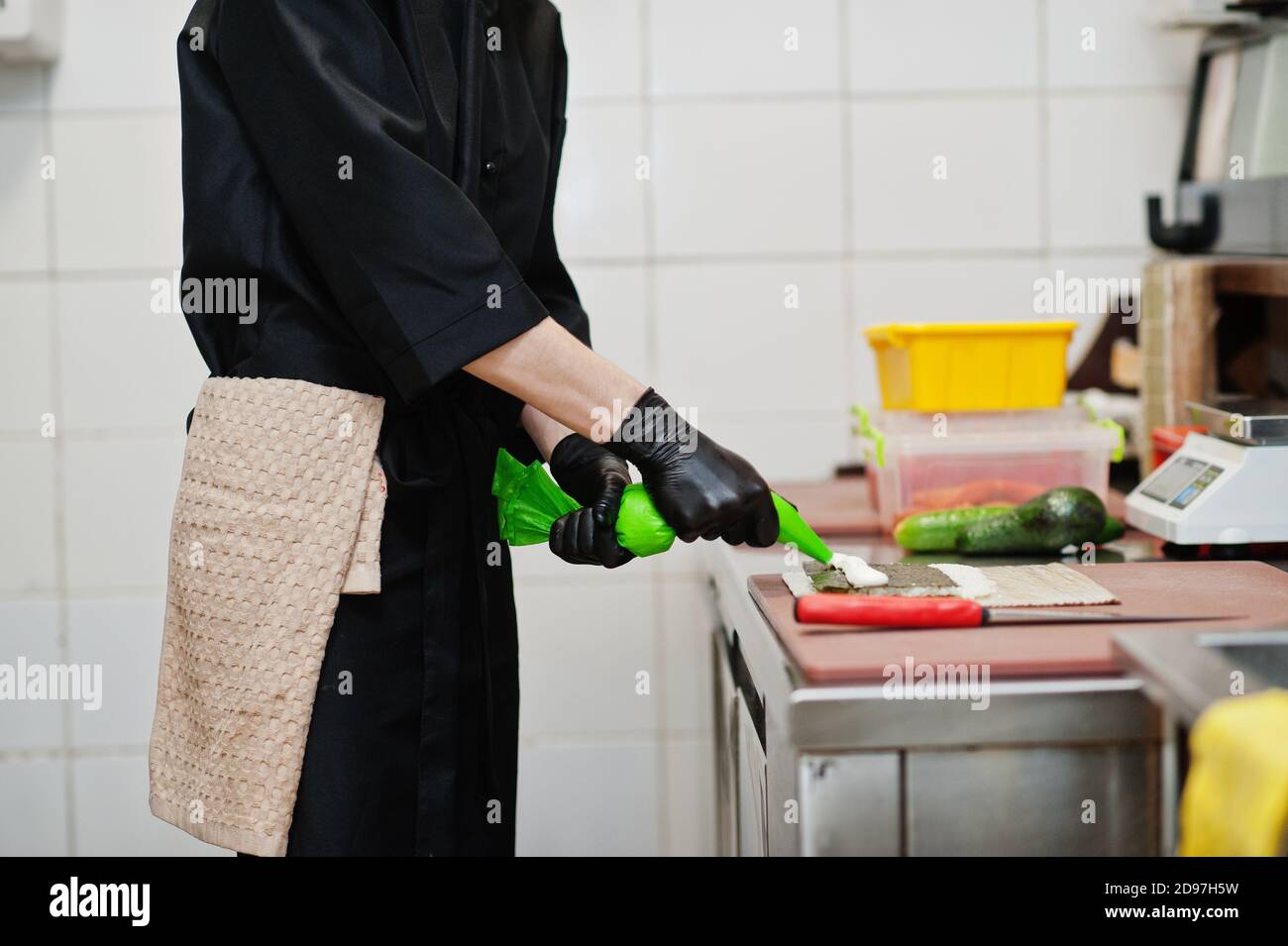 Close up hands of professional chef wear in black gloves making sushi ...