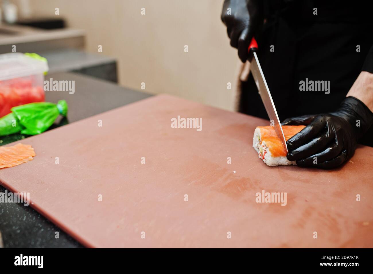 Close up hands of professional chef wear in black gloves making sushi ...