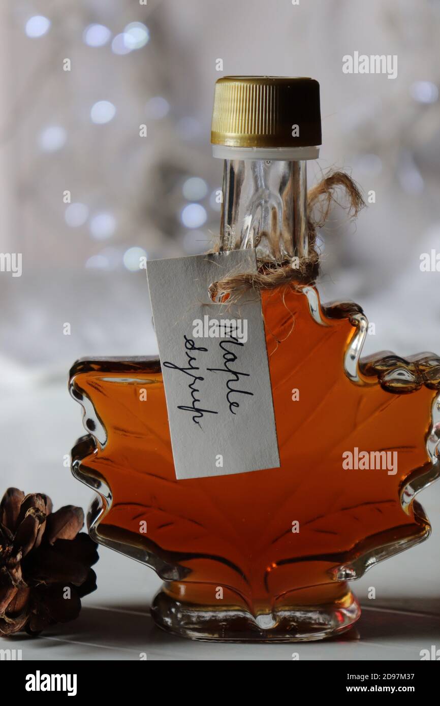 Maple syrup in a maple leaf shaped bottle with handwritten tag and pine ...