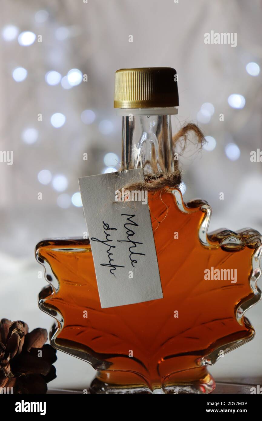 Maple syrup in a maple leaf shaped bottle with handwritten tag and pine ...
