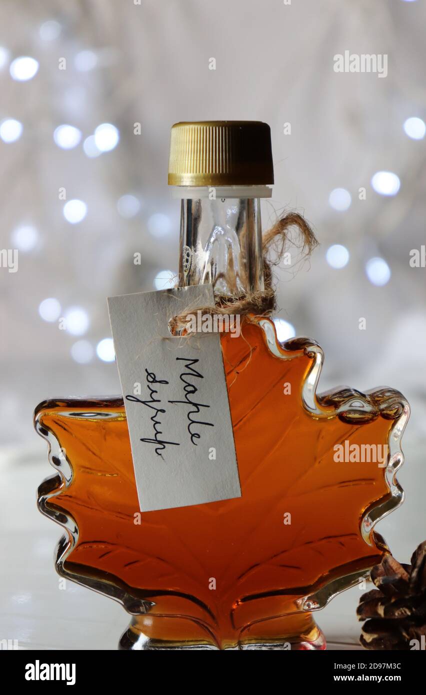 Maple syrup in a maple leaf shaped bottle with handwritten tag and pine ...