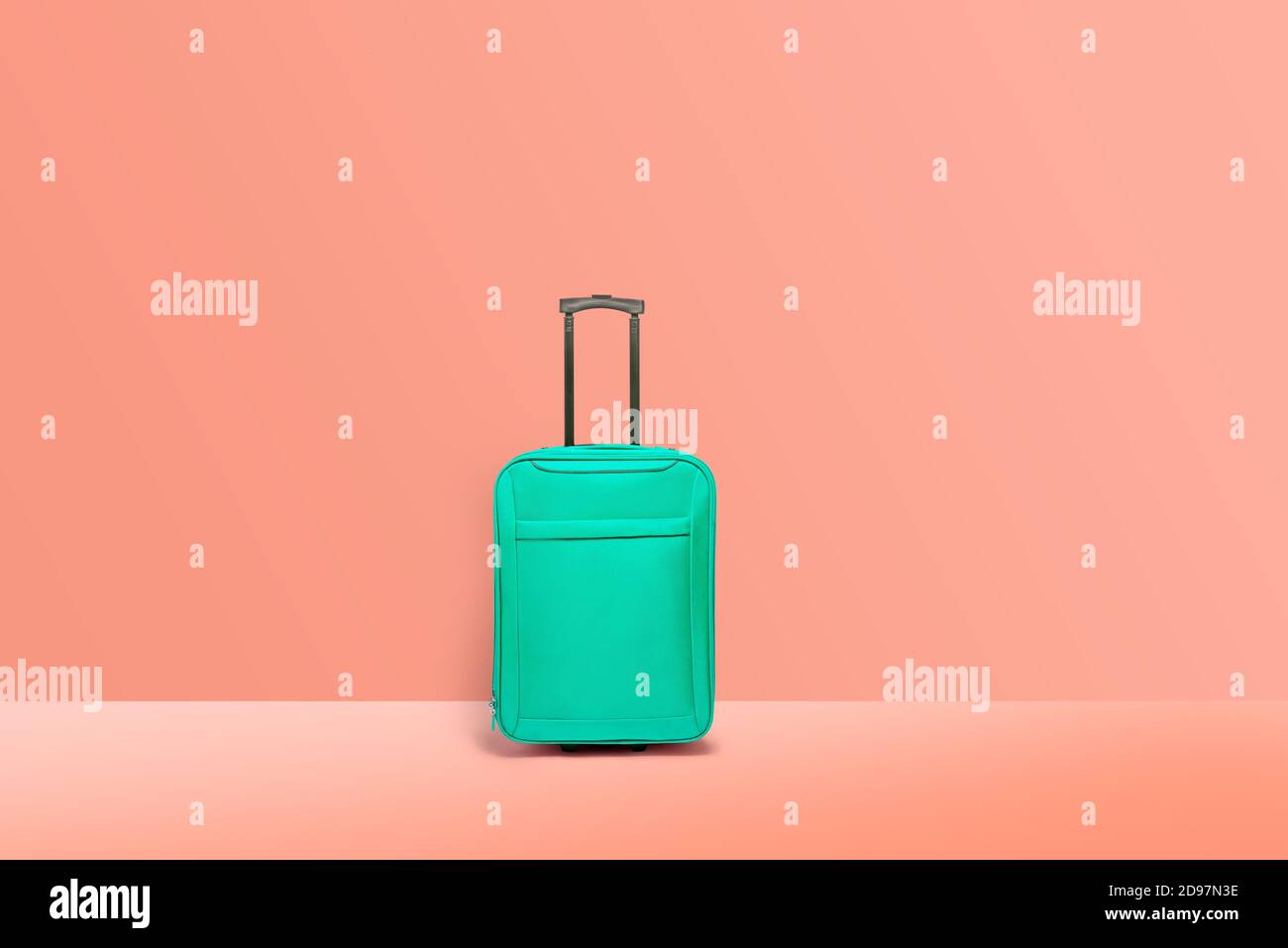 Turquoise suitcase standing in the pink room. Concept of tourism and ...