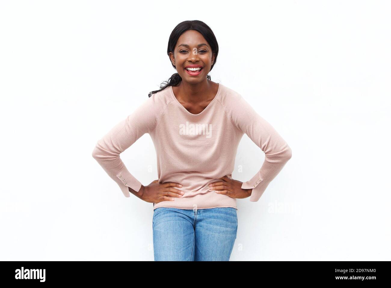 Portrait of happy young black woman laughing with hands on hips against ...