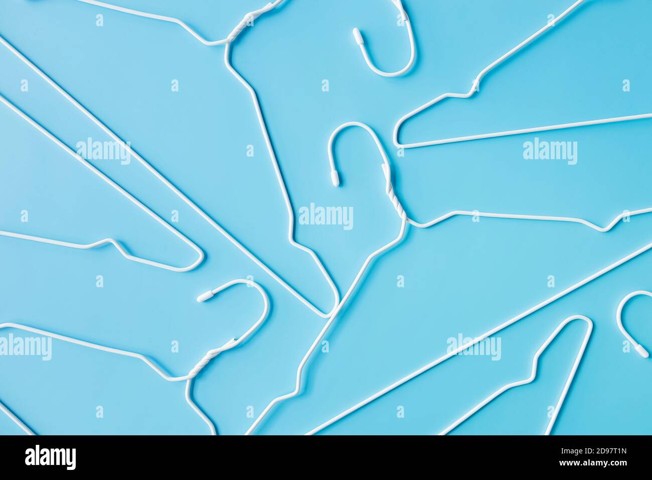 White metal hangers on blue background minimalist style Stock Photo - Alamy