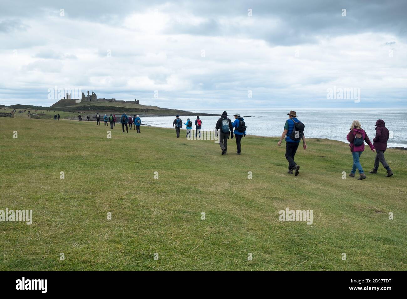 Hiking Group walk Towards Dunstanburgh Castle Northumberland UK Stock ...