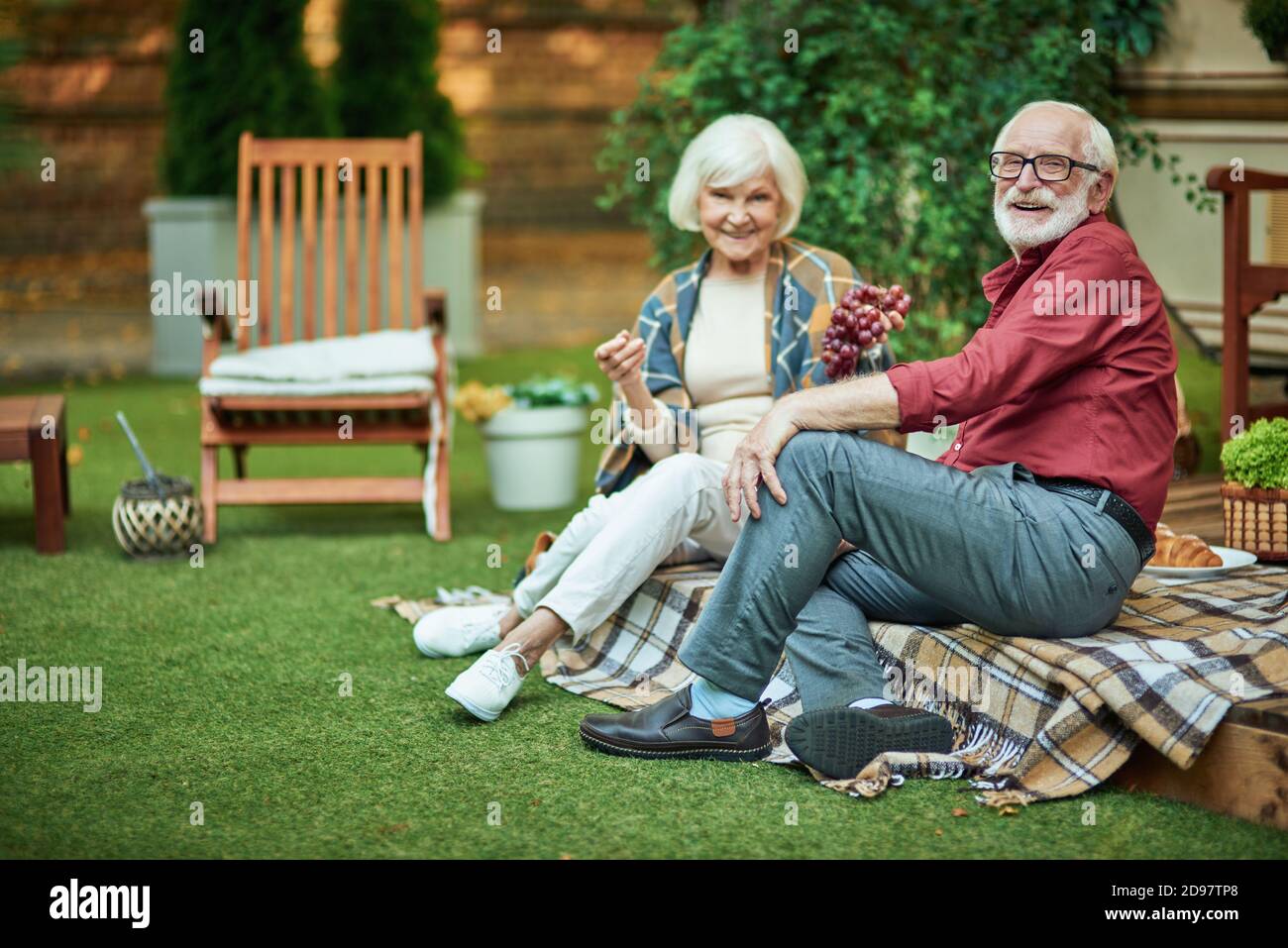 Full Length Photo Of Smiling Senior Couple Sitting Together On The Van