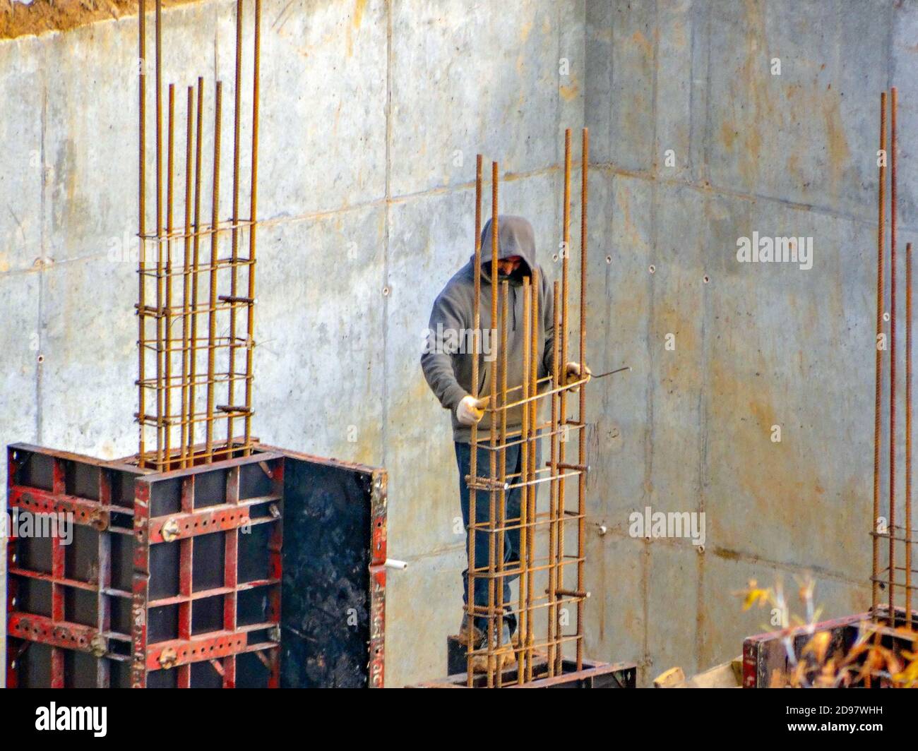 A worker builds a frame for walls in a building under construction ...