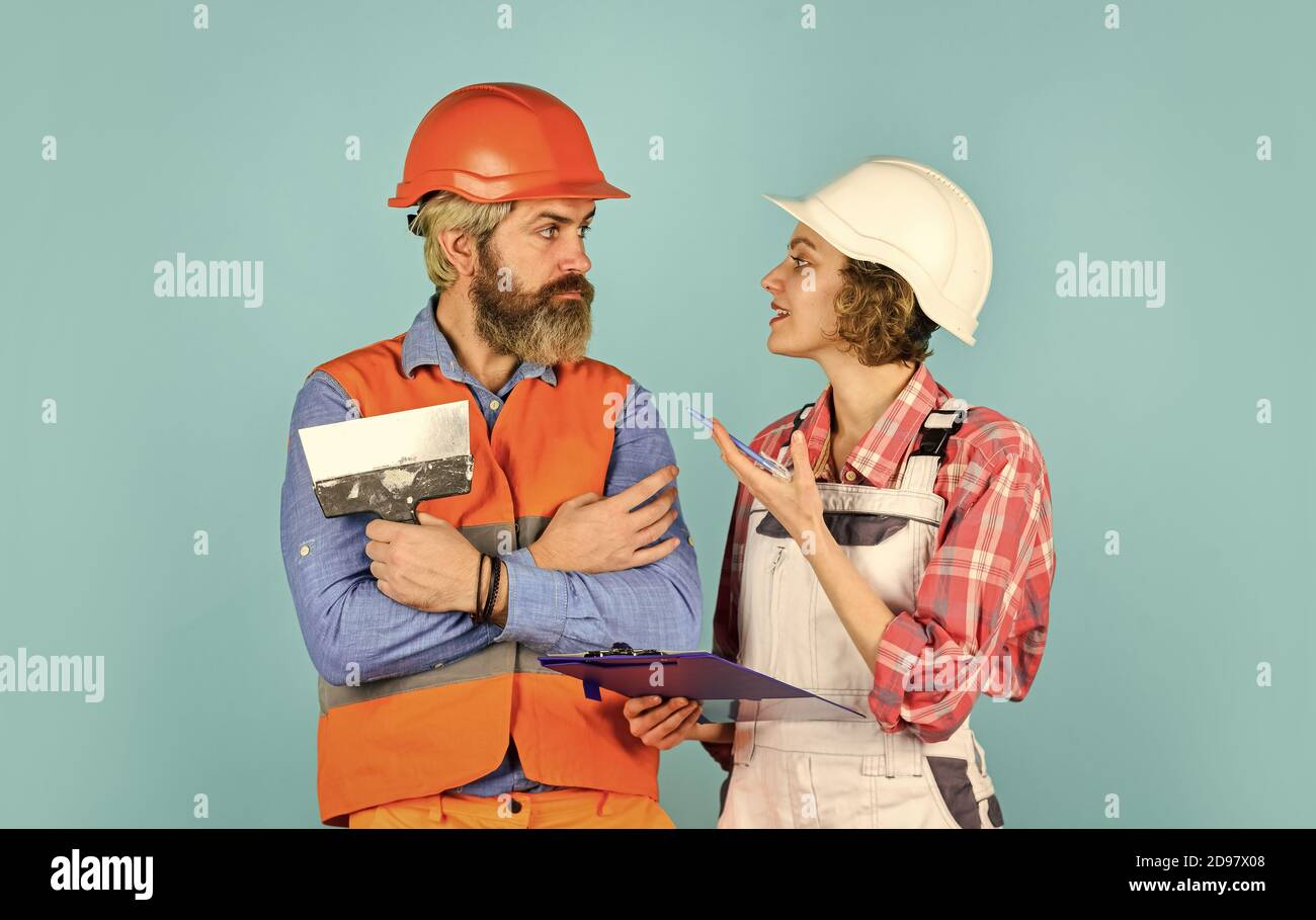 two parters. couple looking at a blueprint. woman and man wear safety ...