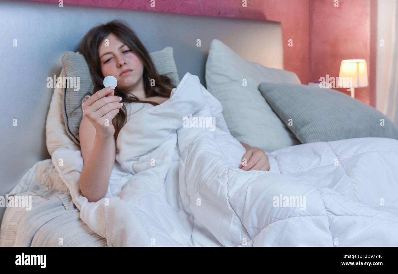 Teenage girl is very cold and feverish. She is lying on her bed Stock ...