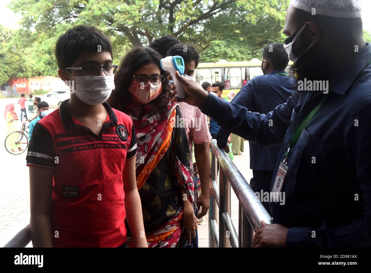 A security personal checks the body temperature of visitors during ...