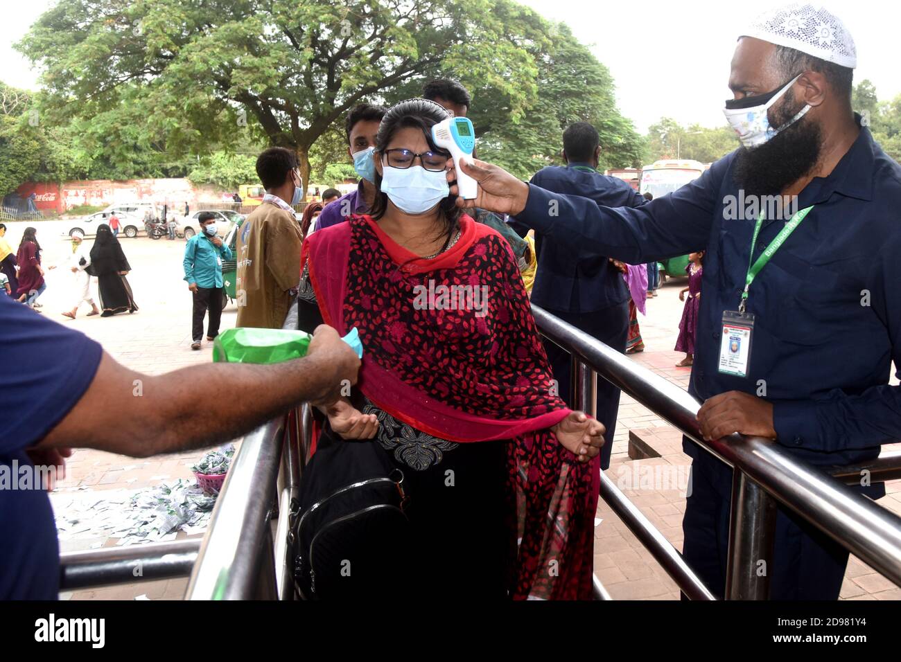 A security personal checks the body temperature of visitors during ...