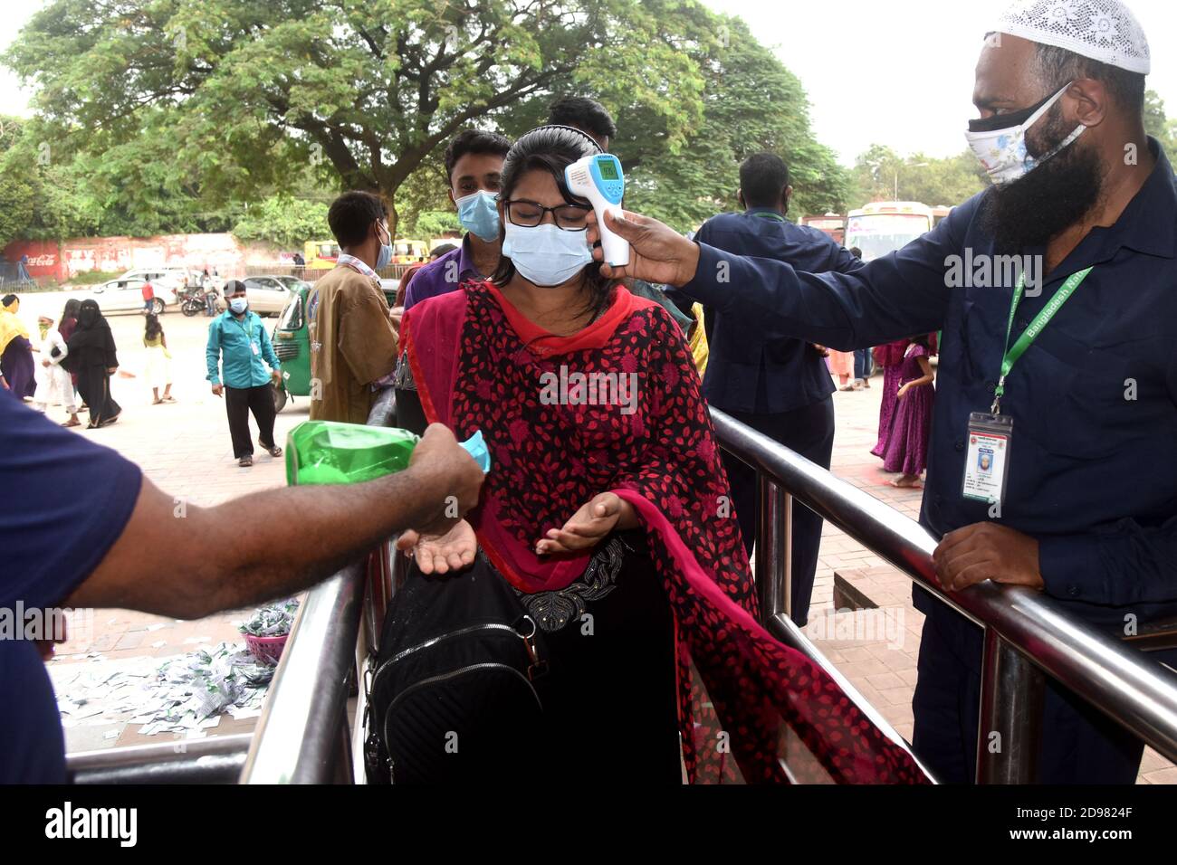 A security personal checks the body temperature of visitors during ...