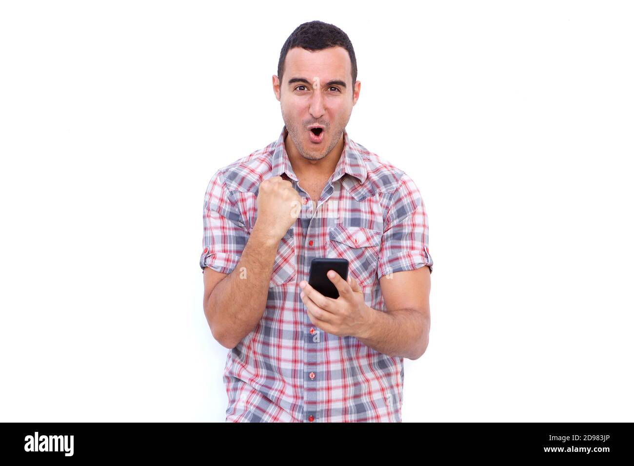 Portrait of man with winning expression holding mobile phone against ...