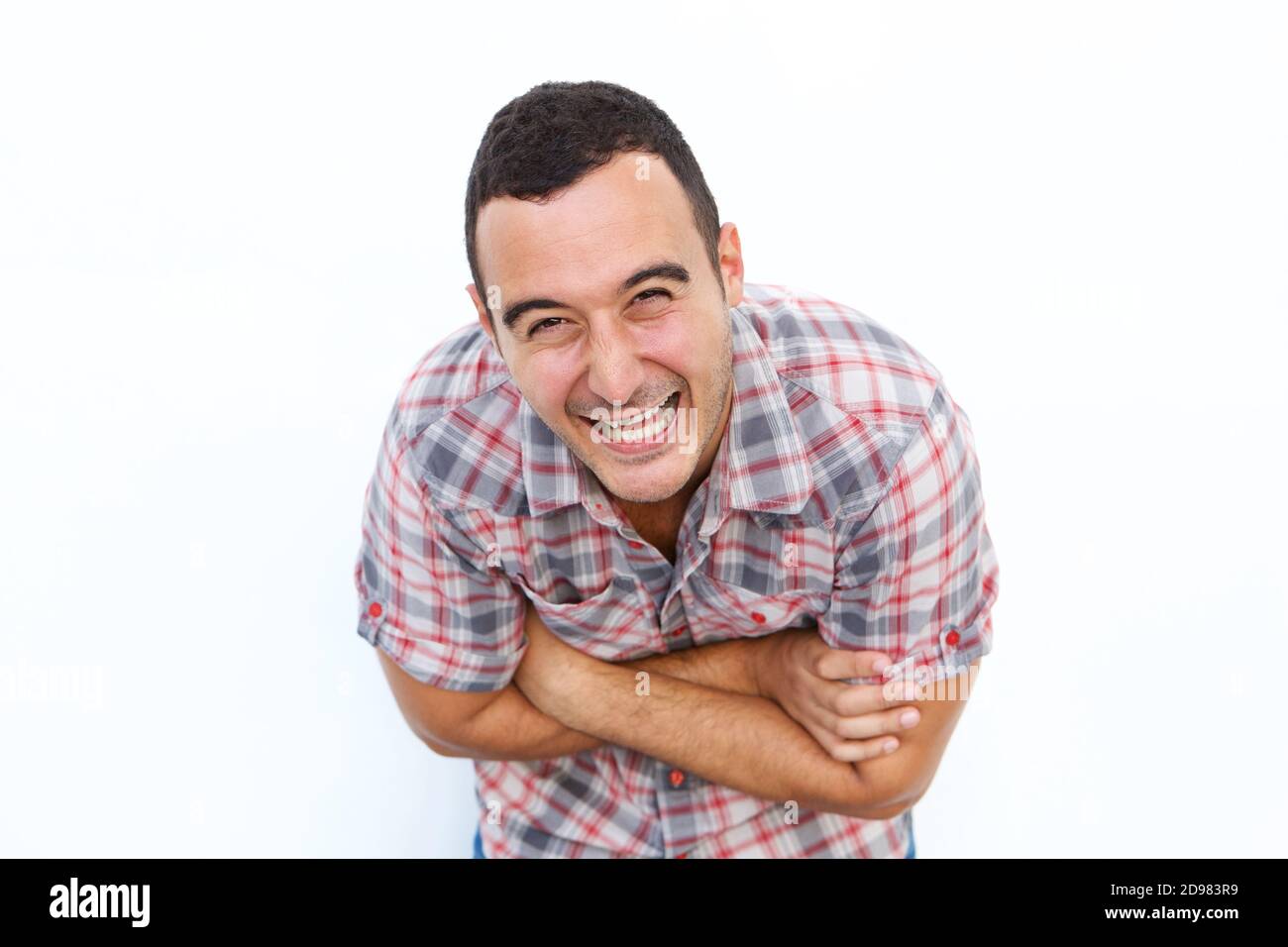 Close up portrait of happy man laughing with arms crossed against ...