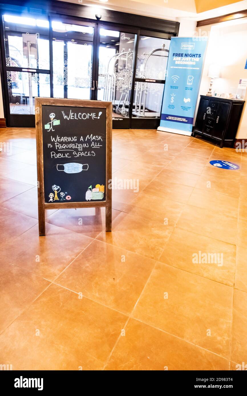 Interior of a hotel lobby featuring a chalkboard mentioning mask ...