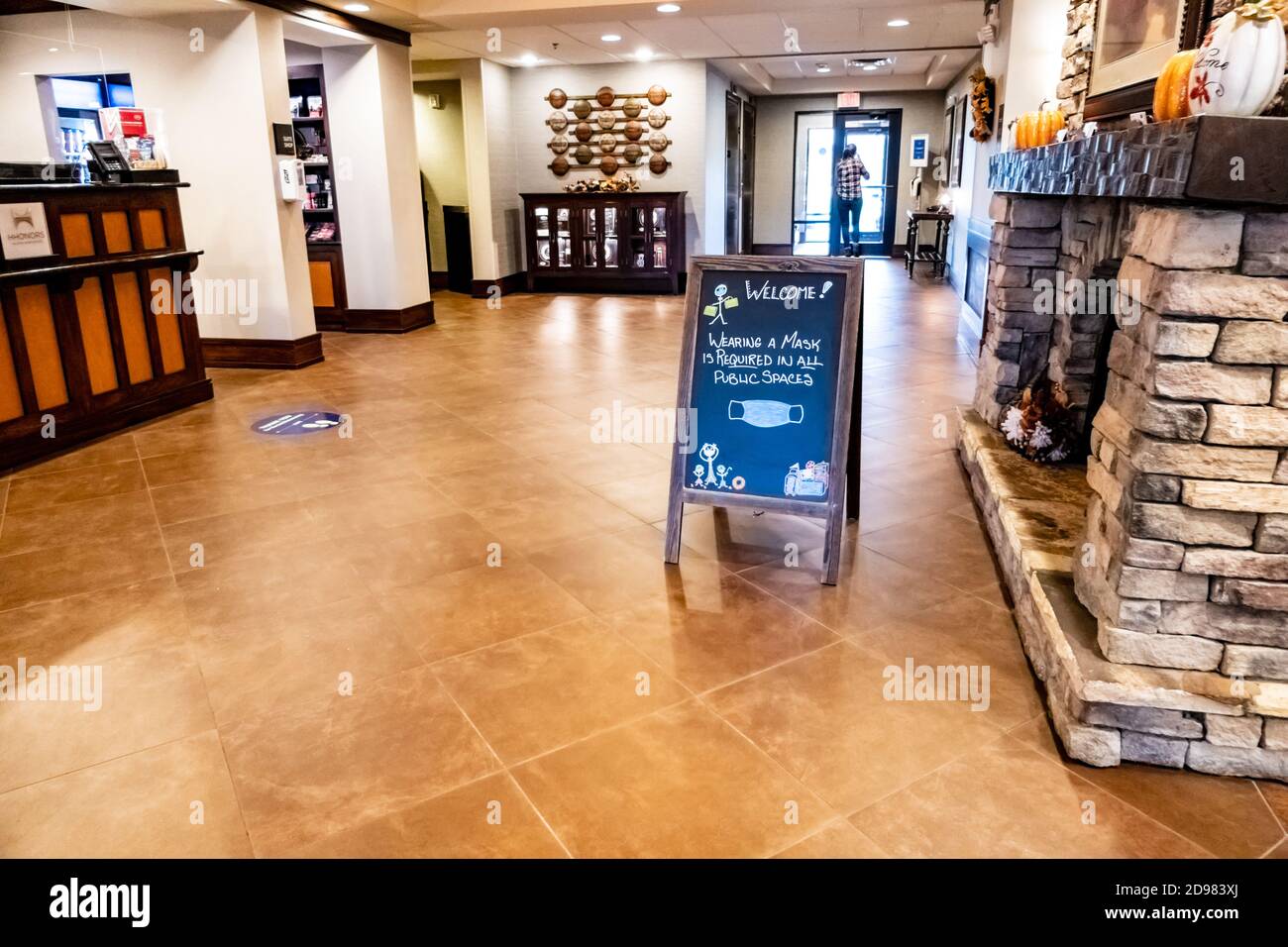 Interior of a hotel lobby featuring a chalkboard mentioning mask ...