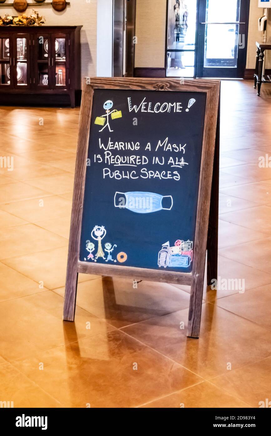 Interior of a hotel lobby featuring a chalkboard mentioning mask ...