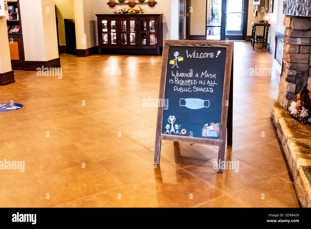 Interior of a hotel lobby featuring a chalkboard mentioning mask ...