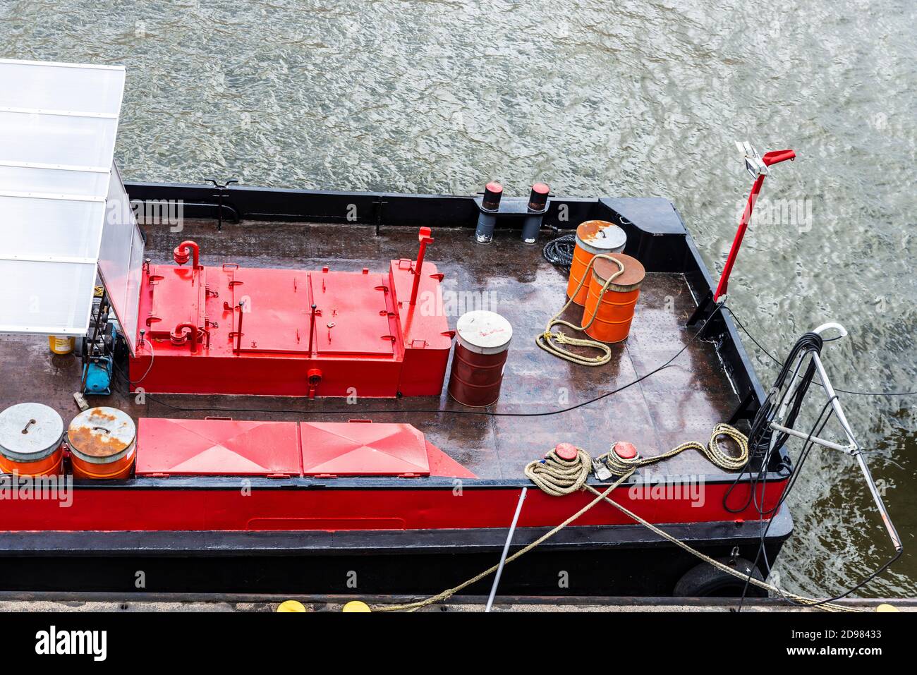 Deck of a industrial ship with barrels and ropes moored in the harbor ...