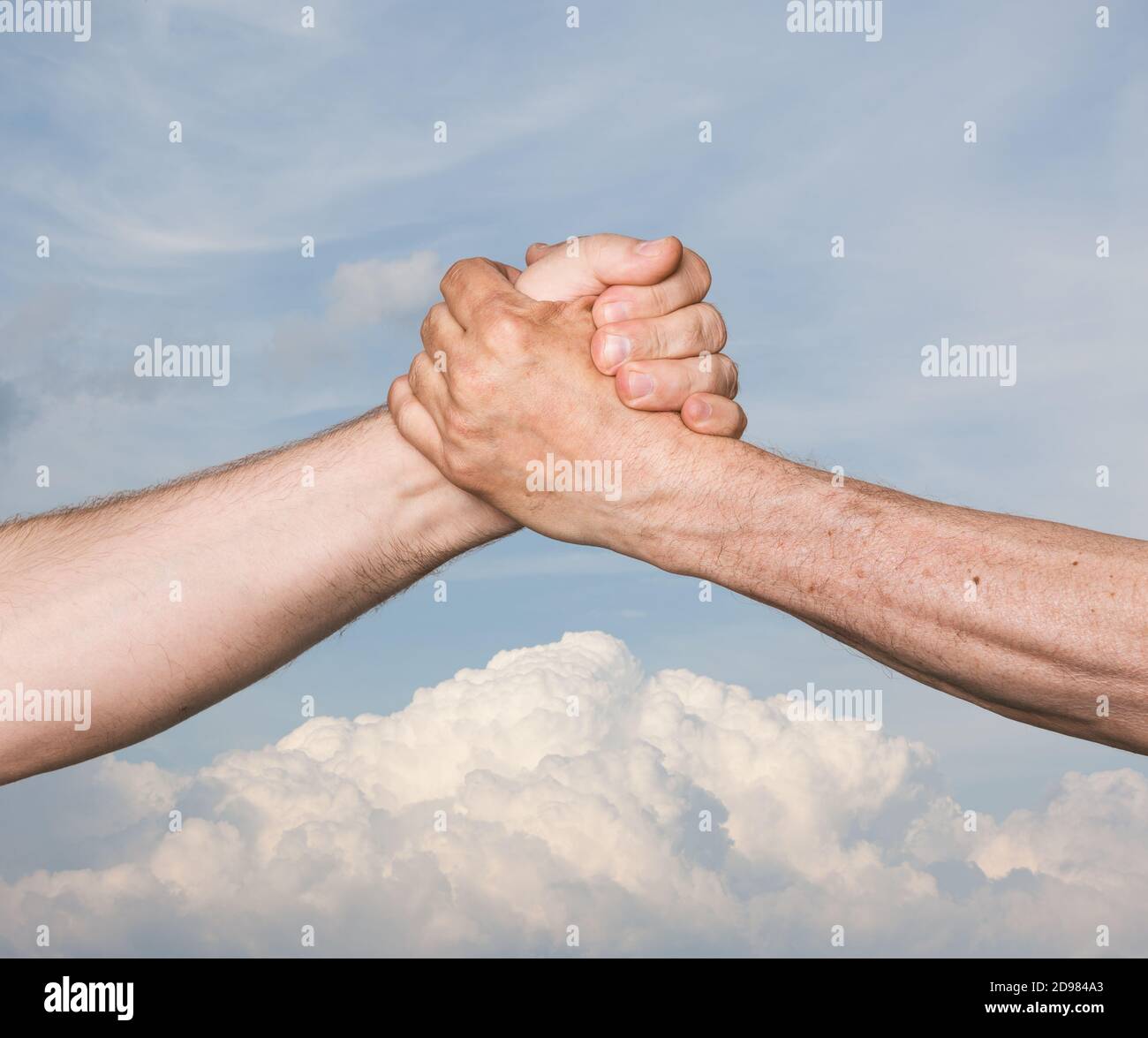 Shaking hands of two male people against the blue sky Stock Photo - Alamy