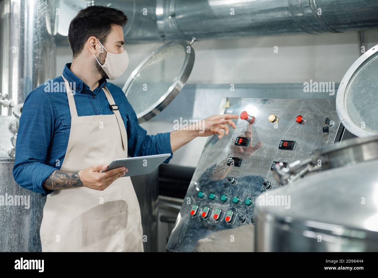 Worker starts production of craft beer at factory at covid-19 pandemic ...