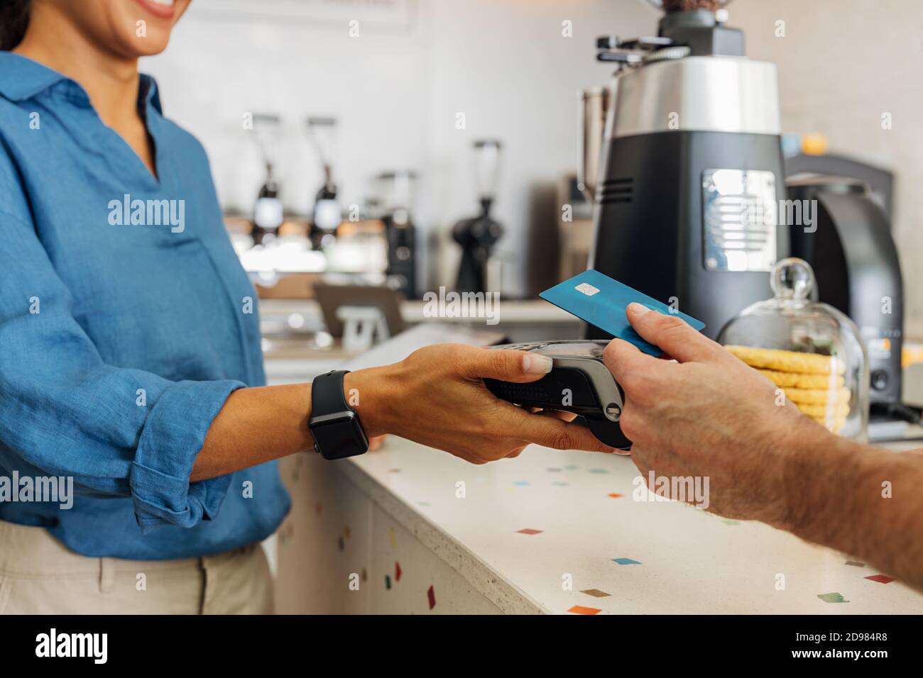 Unrecognizable female employee taking payment from customer in coffee ...