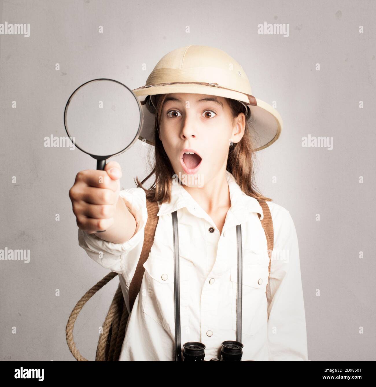 little explorer looking through magnifying glass on gray background ...