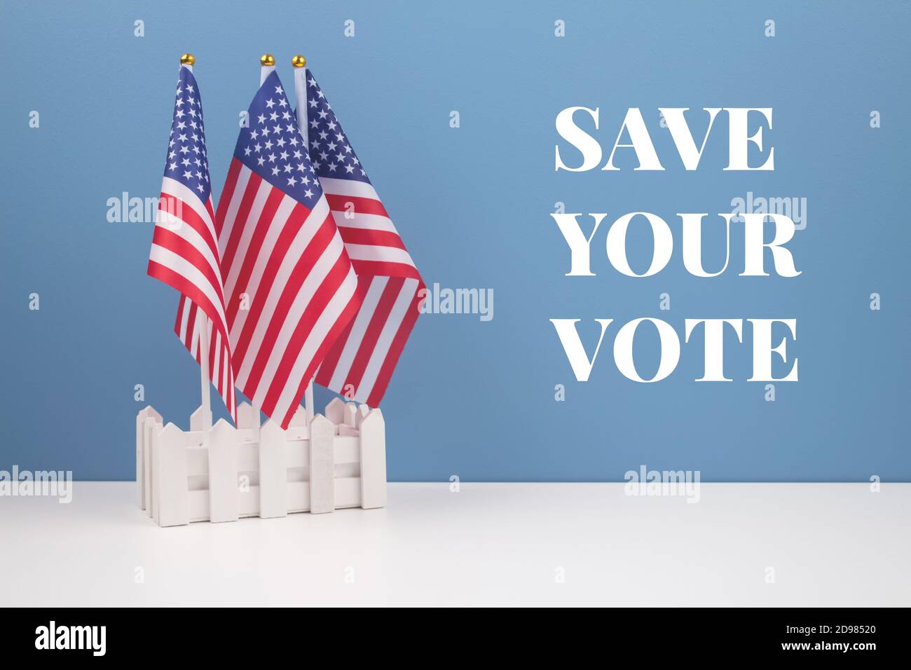 Creative composition with american flags on white table with blue wall ...